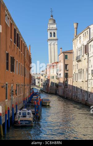Venice canal view with leaning bell tower at peaceful daylight. San ...