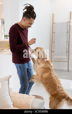 Man feeding golden retriever with dog food near plant Stock Photo - Alamy