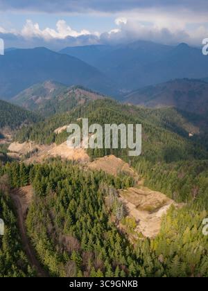 Aerial view of rugged, textured brown landscape with scattered green ...