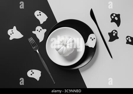 Table setting with paper ghosts for Halloween party on color background ...