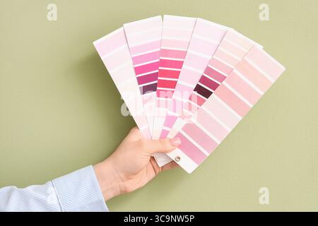 Female hand with pink color palettes on green background Stock Photo ...