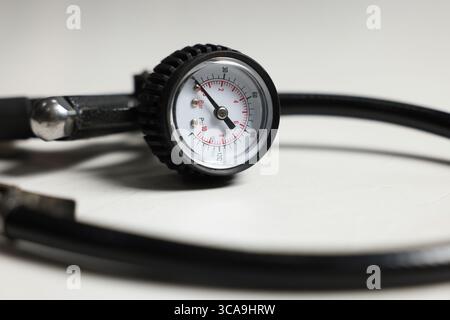 One tire inflation gun with gauge on light background, top view. Space ...