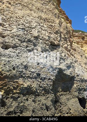 A dramatic coastal landscape showing steep green cliffs topped with ...