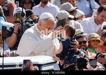 Pope Leo XIV greets a child as he arrives for his weekly general ...