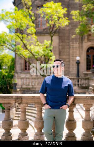 Young handsome tourist man against gray background Stock Photo - Alamy