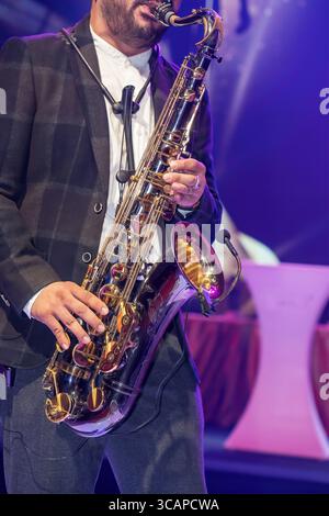 Male musician playing saxophone under blue night sky Stock Photo - Alamy