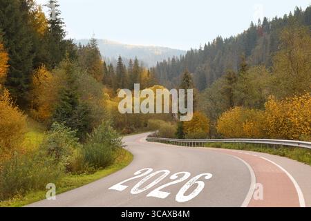 2026 on asphalt road in mountains. Hope and expectation for new year ...