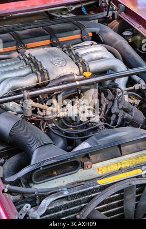 Vintage car engine compartment. An exposed vintage car engine with ...