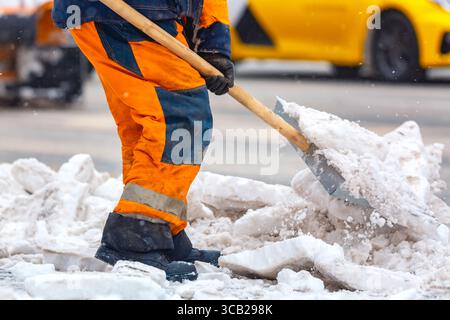A person sweeps snow from a sidewalk during snowfall at the Beijing ...