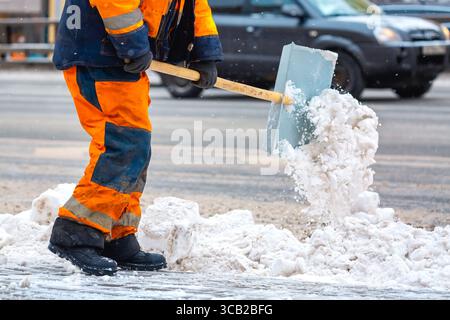A person sweeps snow from a sidewalk during snowfall at the Beijing ...
