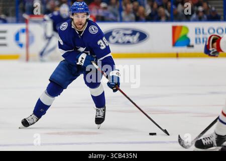 Tampa Bay Lightning's Brandon Hagel, left, skates with the puck past ...