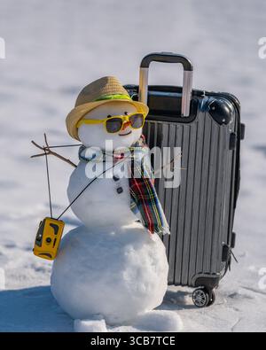 Snowman with suitcase. Winter vacation. Christmas theme Stock Photo - Alamy