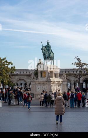 Crowd gathers around majestic statue of King St. Stephen on horseback ...