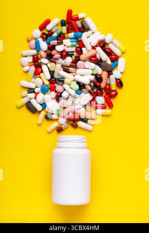 White Pills scattered from white plastic medicine container Stock Photo ...