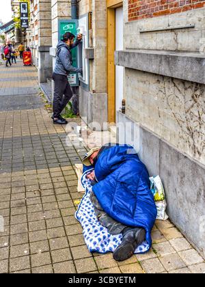 Vagrant homeless man sleeping rough beneath the stone pillars of the ...