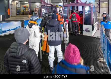 Skiers and tourist boarding Gondola at the Saas-Fee lift station, Visp ...