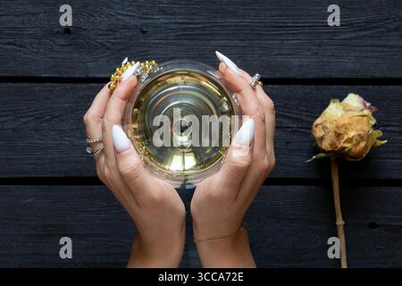 a girl holds a glass of white wine against the backdrop of a lavender ...