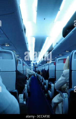 Airplane Aisle with Passengers’ Elbows in Cool Lighting Stock Photo - Alamy