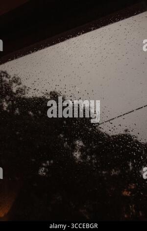 Raindrops and condensation on window at night with street lights ...