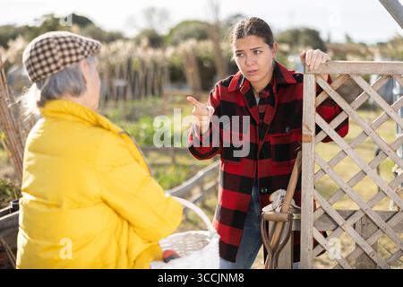 Two angry casual women neighbors of different ages arguing during the ...