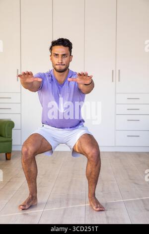 a living room with wood flooring and white couches in the center of the ...