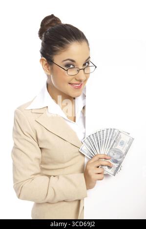 Businesswoman holding money with smile isolated on white background ...