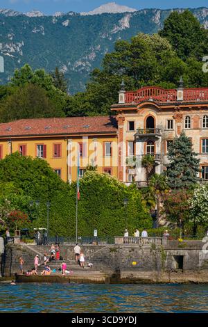 Sun bathers on stone steps at the shoreline of Lake Como, Bellagio ...