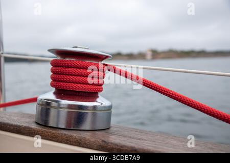Sailboat winch with red rope of genoa headsail sheet on yacht deck ...