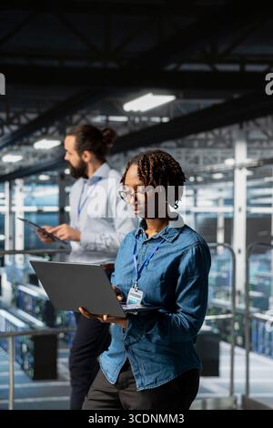 Data center programmer checking lines of code and colleague reviewing ...