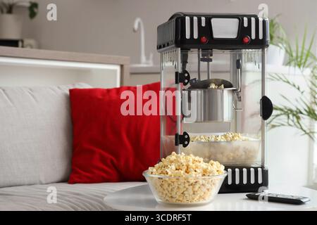 Modern popcorn machine and TV remote on coffee table in living room ...