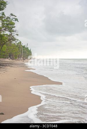 Gentle ocean waves lapping against a sandy beach, creating a smooth ...