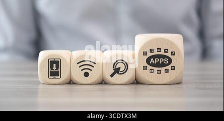 Wooden blocks with symbol of mobile apps concept on blue background ...