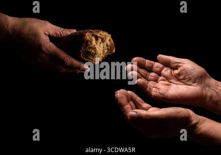 Poverty concept. Dirty hands giving bread isolated on balck background ...