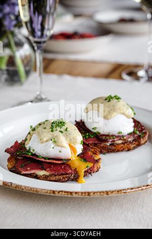 Delicious Eggs Benedict Served With Fresh Greens in a Cozy Cafe Setting ...