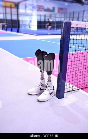 A pair of below-knee prosthetic legs, standing side-by-side on the edge ...