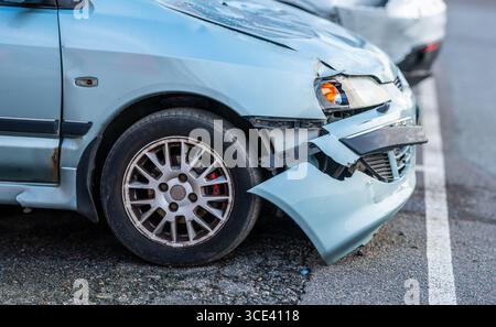 Badly damaged front light and bumper of a blue car Stock Photo - Alamy