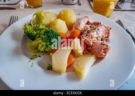 baked vegetables with boiled fish on white plate on ceramic Stock Photo ...