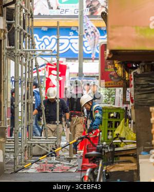 Japanese construction workers building scaffolding in Akihabara ...