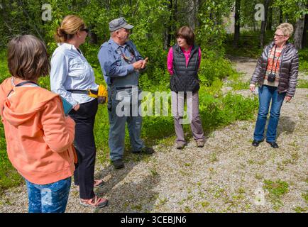 Alaska Railroad guide speaking to a group of passengers on a tour of ...