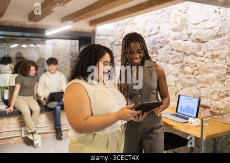 Two diverse women discussing business ideas and working together in a ...