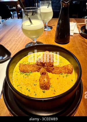 Golden crispy fried shrimp arranged on white textured plate. Lime ...