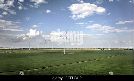An aerial view of windmill in lush green countryside with streams on a ...