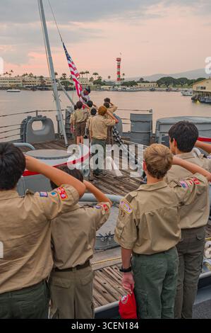 Group of Boy Scouts standing at attention and saluting as the flag of ...