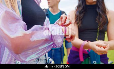 Close Up Of Friends At Entrance To Music Festival Putting On Security ...