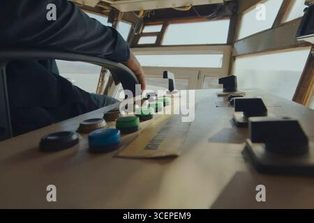 The excavator control panel buttons and the operator's hand nearby ...