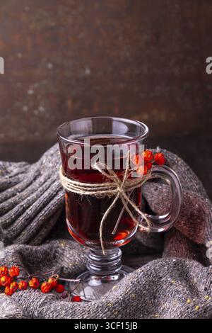 Dried Rowan berries in a glass jar on a white table. Selective focus ...
