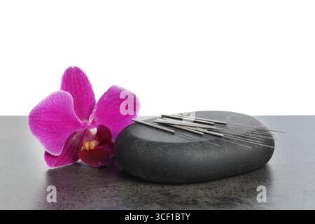 Acupuncture needles and spa stone on table, closeup Stock Photo - Alamy