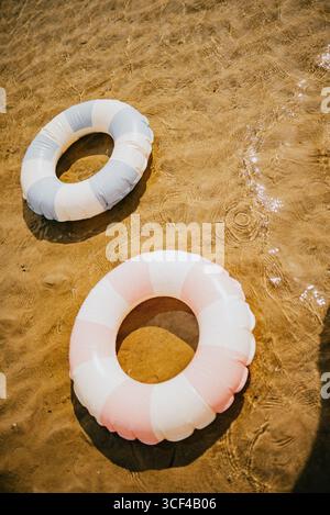 Bright pink inflatable circle with white handles and a shadow on a ...