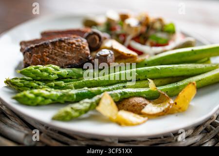 grilled juicy mushrooms on a plate on a dark wooden table, horizontal ...