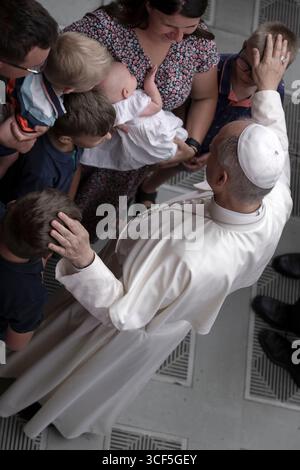 Pope Leo XIV greets a family during his weekly general audience in St ...